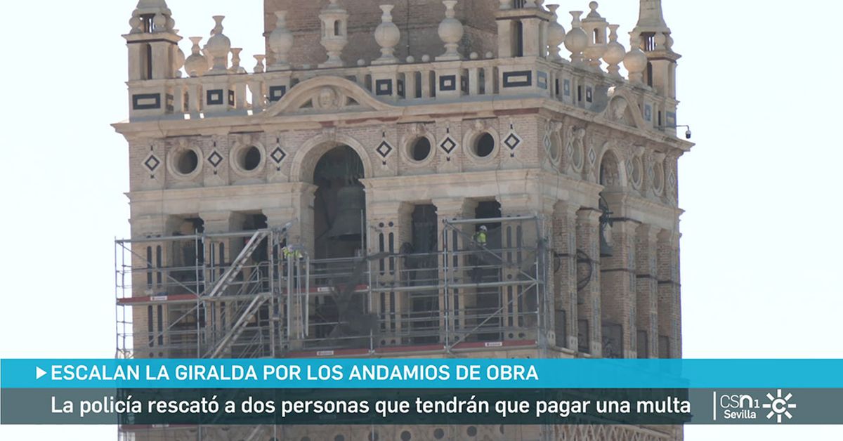 Una pareja escala la Giralda por el andamio instalado para su restauración